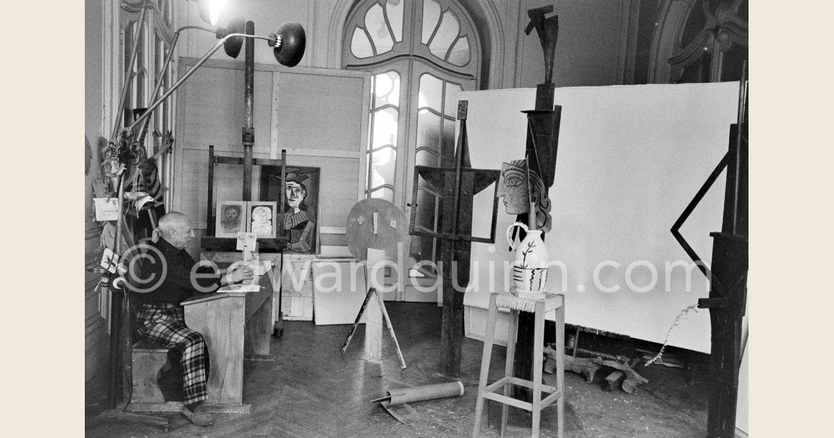 Pablo Picasso sitting at a school bench. Dressed in the checkered ...